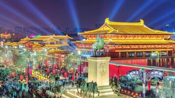 Um edifício tradicional chinês com arquitetura elaborada e uma estátua de uma figura a cavalo.