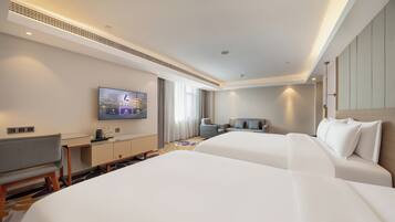 Quarto de hotel com duas camas, uma escrivaninha, uma cadeira, uma televisão e uma janela grande.