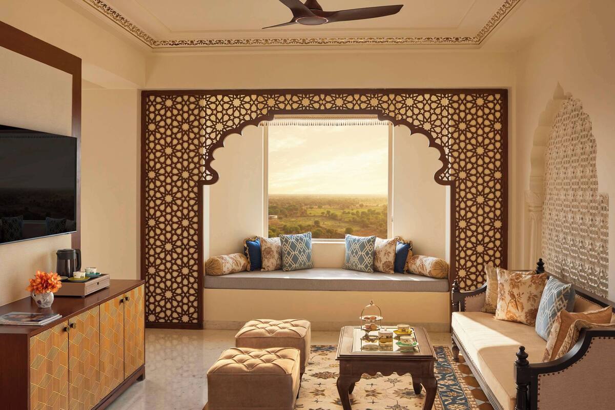 Quarto com sofá-cama, televisão, biombos decorativos e vista para a paisagem.