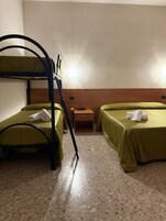 Quarto com beliche, uma mesa de cabeceira e uma luminária fixada na parede.