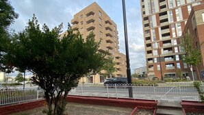 Um edifício moderno com vários andares, com varandas e grandes janelas.