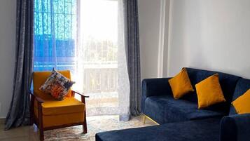 Apartamento Deluxe, varanda, Vista para a cidade | Sala de estar | Smart TV de 24 polegadas com canais digitais