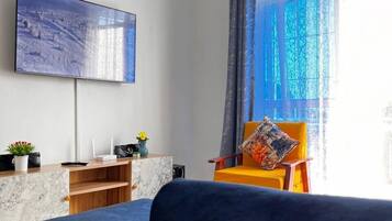 Apartamento Deluxe, varanda, Vista para a cidade | Sala de estar | Smart TV de 24 polegadas com canais digitais