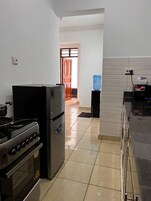 Uma cozinha com fogão, geladeira e bebedouro.