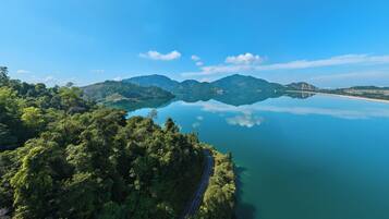 Um lago sereno rodeado por vegetação exuberante e montanhas.