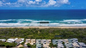 Vista aérea de Castaways Beach, com uma placa indicando a localização.
