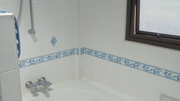Casa de banho com banheira, chuveiro e janela.