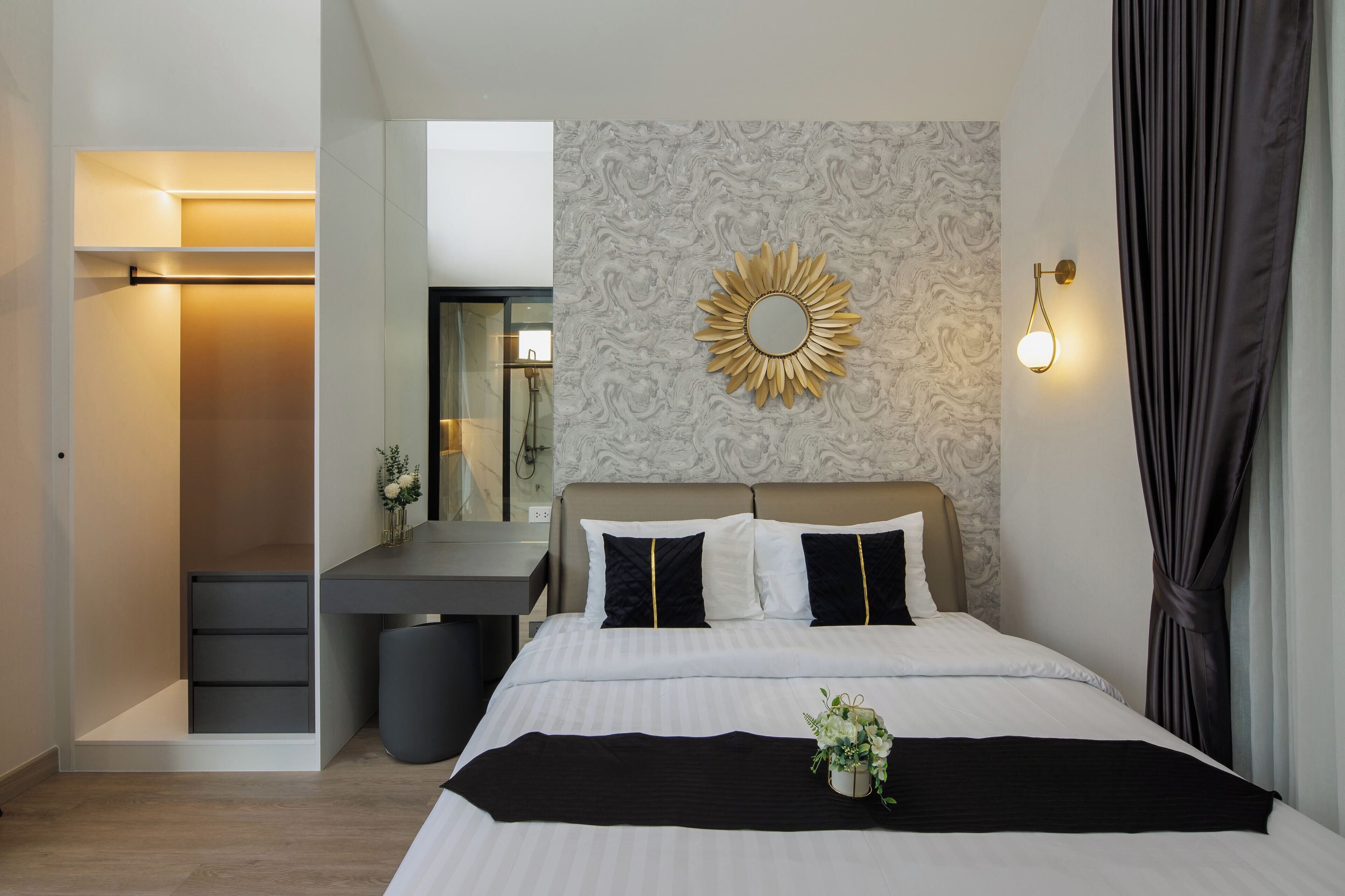 Quarto de hotel moderno com uma cama, mesa de cabeceira e espelho.