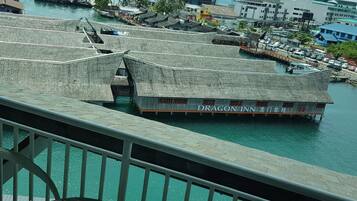 Um imóvel à beira-mar com o edifício Dragon Inn, um cais e vista para o mar.