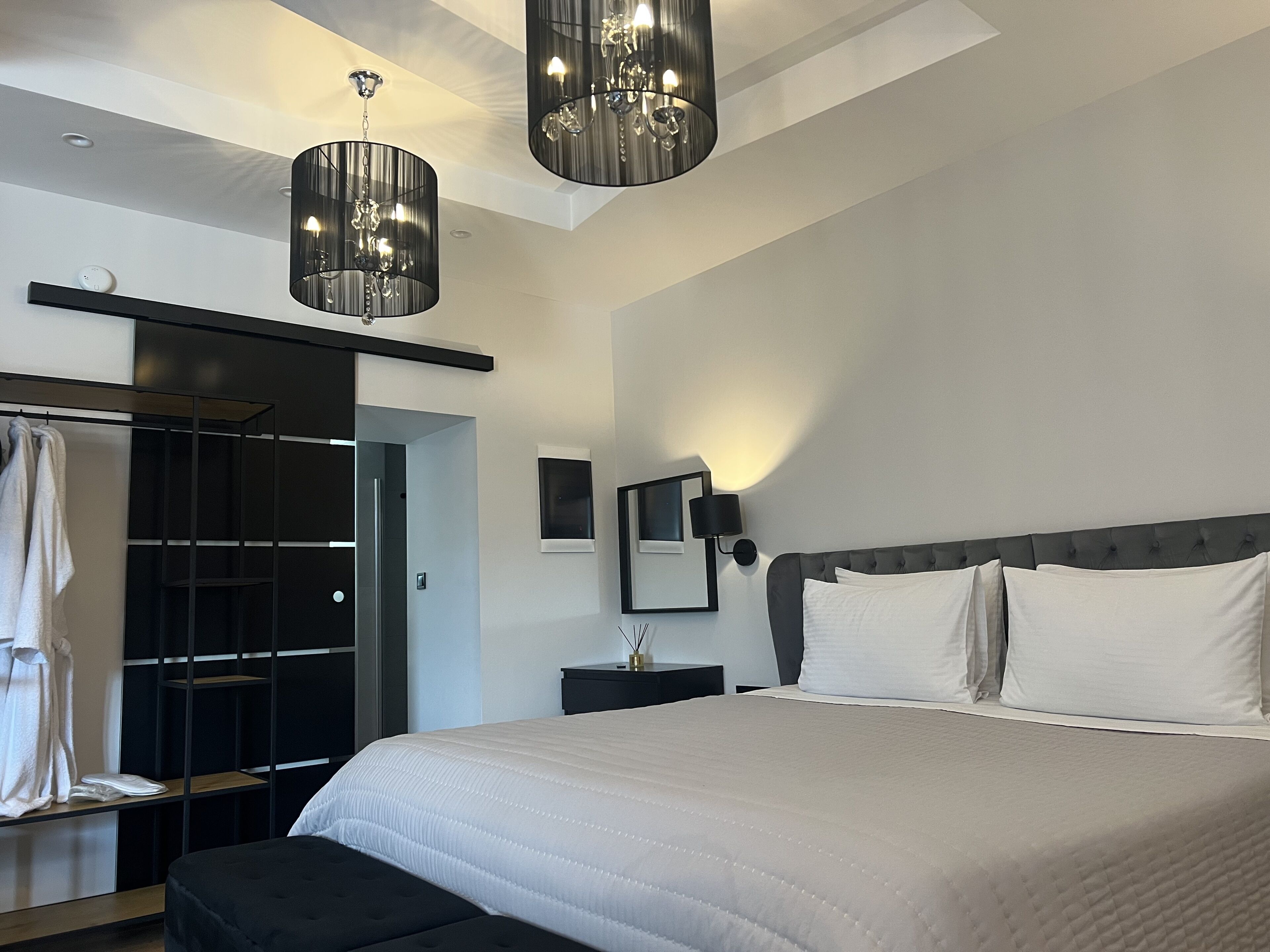 Quarto moderno com uma cama grande, um guarda-roupa e um espelho.
