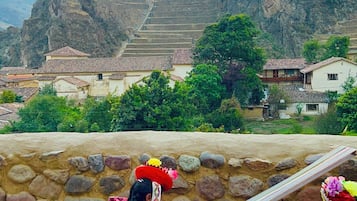Uma aldeia andina tradicional com edifícios de pedra e campos em socalcos.