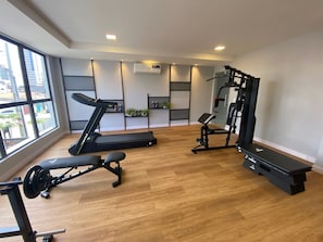 Uma academia moderna em casa com esteira, supino e banco de musculação.