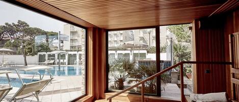 Um deck de madeira com piscina, área de estar ao ar livre e vista para a cidade.
