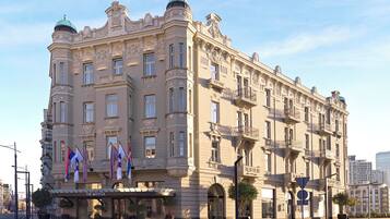 Um edifício histórico com arquitetura elaborada, várias varandas e bandeiras.