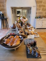 Um buffet de café da manhã com diversos pães, doces e acompanhamentos.