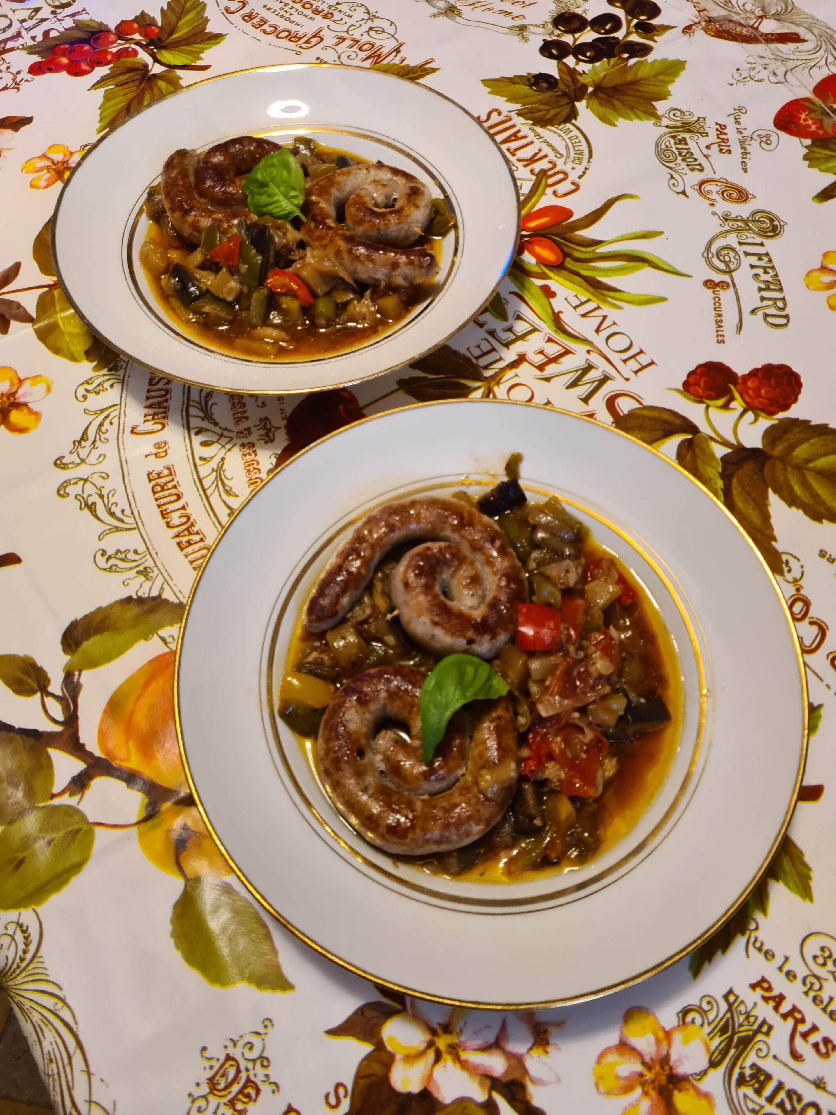 Duas travessas de comida sobre uma toalha de mesa florida.