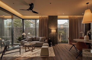 Uma sala de estar moderna com sofá, mesa de centro e área de jantar.