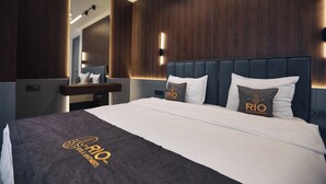 Quarto de hotel com uma cama grande, paredes de painel de madeira, uma mesa de cabeceira e um espelho.