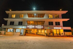 Um hotel de dois andares com uma placa indicando 'Hotel Regalia Comfort' e uma placa 'treebo'.