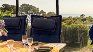 Mesa posta para dois, vista para o mar e vegetação.