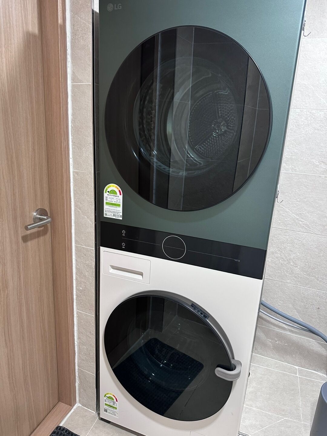 Uma máquina de lavar e secar compacta com painel de controle, porta e etiqueta na frente.