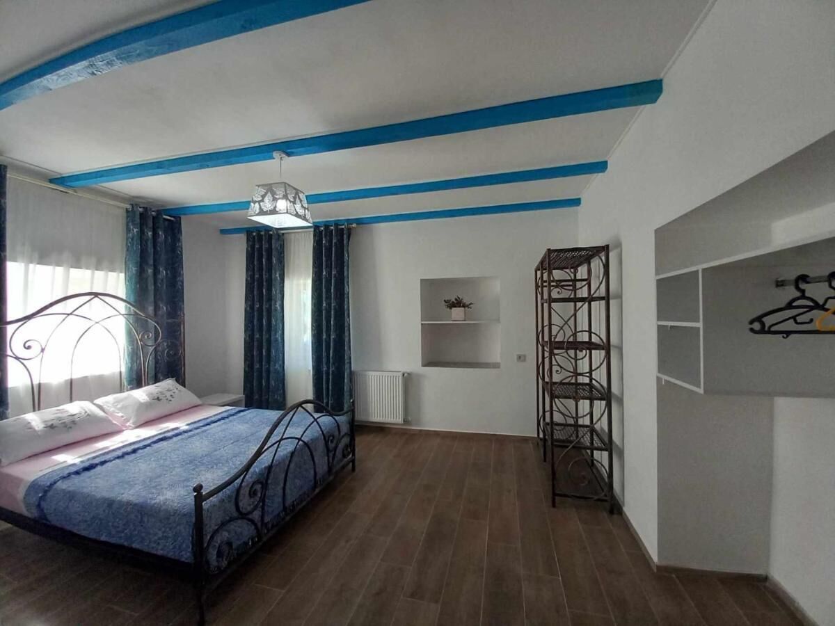 Quarto com cama, radiador, prateleira e suporte de metal.