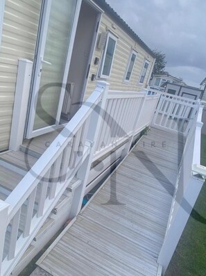 Uma fileira de casas móveis com grades brancas e um deck de madeira.