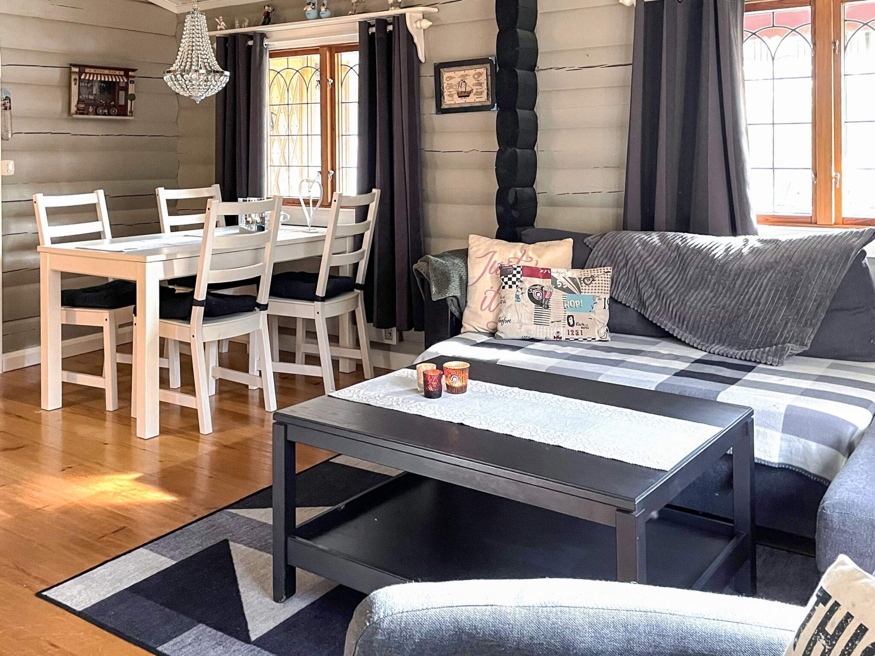 Uma sala de estar acolhedora com sofá, mesa de centro e área de jantar com cadeiras e mesa.
