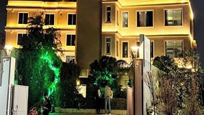 Hotel de vários andares com varandas iluminadas e uma placa indicando um restaurante.