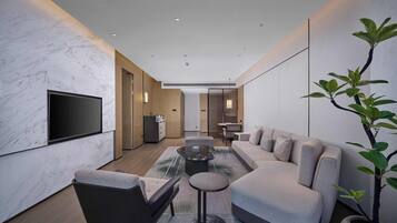 Uma sala de estar moderna com um sofá modular, uma mesa de centro e uma TV fixada na parede.