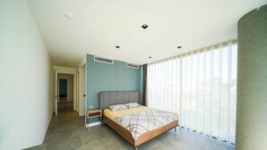 Quarto moderno com cama, mesa de cabeceira e janela com persianas.