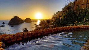 Piscina com vista para o oceano e uma linha costeira rochosa.