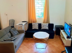 Apartamento superluxo, 1 cama Queen e sofá-cama, vista para o jardim, no piso térreo | Área de estar | TV de tela plana