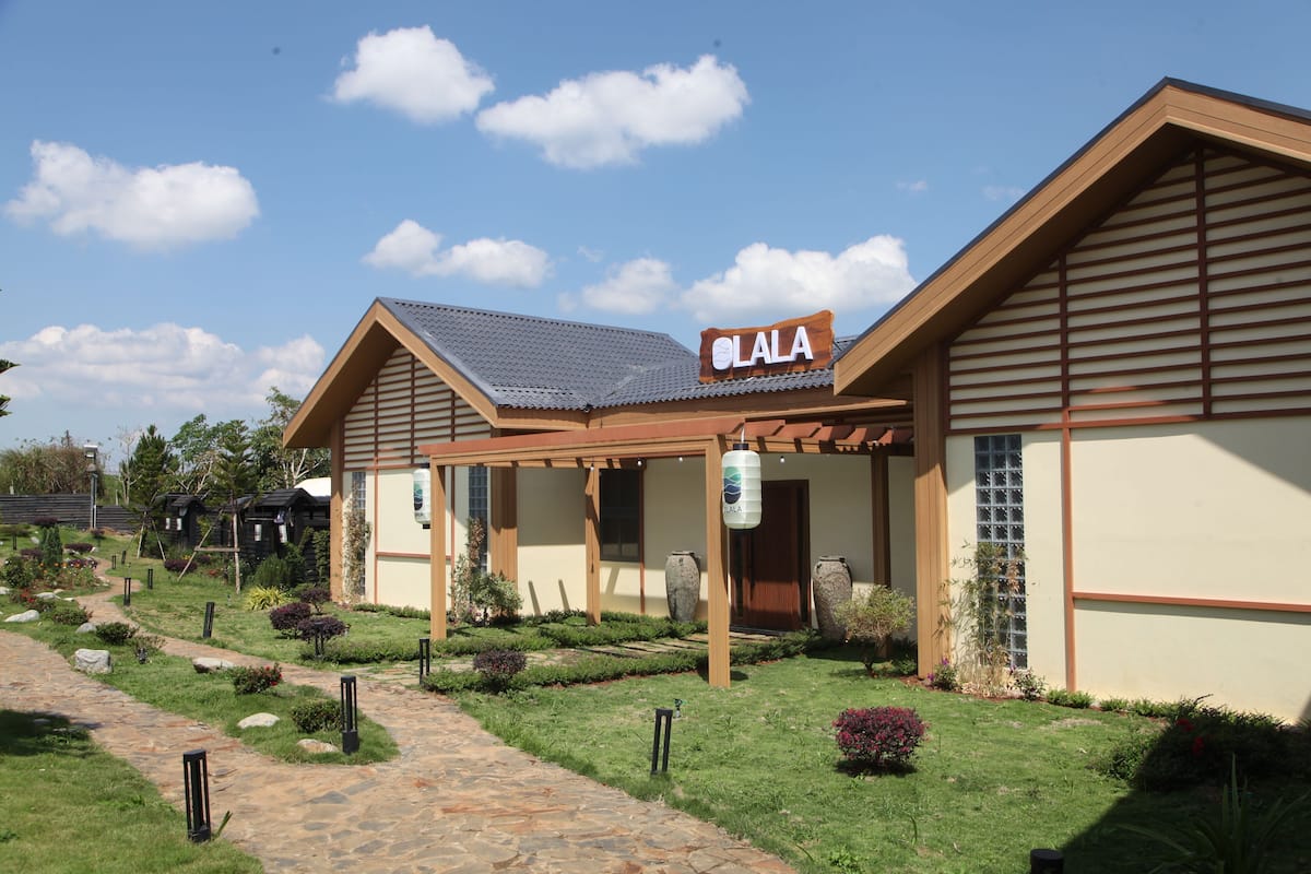 Um edifício com uma placa que diz “LALA” e uma entrada coberta.