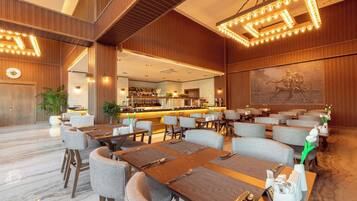 Um restaurante moderno com área de bar, painéis de madeira e um grande mural.