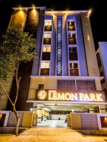 Um edifício de hotel moderno com uma placa visível que diz "Hotel Lemon Park".