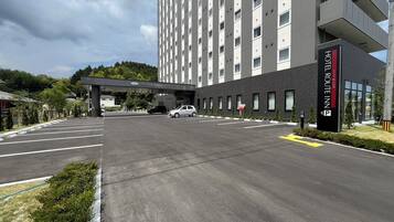 Entrada moderna de um hotel com estacionamento, uma cobertura e a placa Hotel Route Inn.