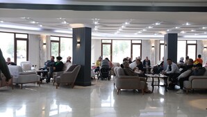 Um hall amplo com mobiliário moderno, janelas grandes e piso lustroso.