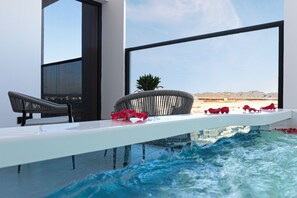 Uma área interna de piscina moderna com vista para uma paisagem montanhosa.