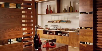 Uma cozinha moderna com armários de madeira, uma mesa de jantar e uma bancada com alimentos.