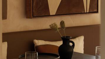 Uma mesa de jantar com pratos, talheres e um vaso com flores.