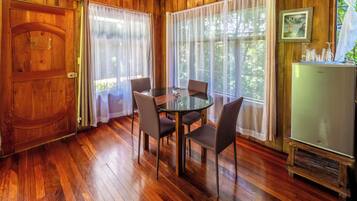Interior de madeira com uma mesa de jantar, cadeiras e uma geladeira.