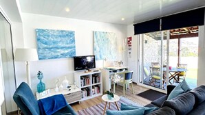 Uma sala de estar moderna com um sofá, uma televisão e uma estante.