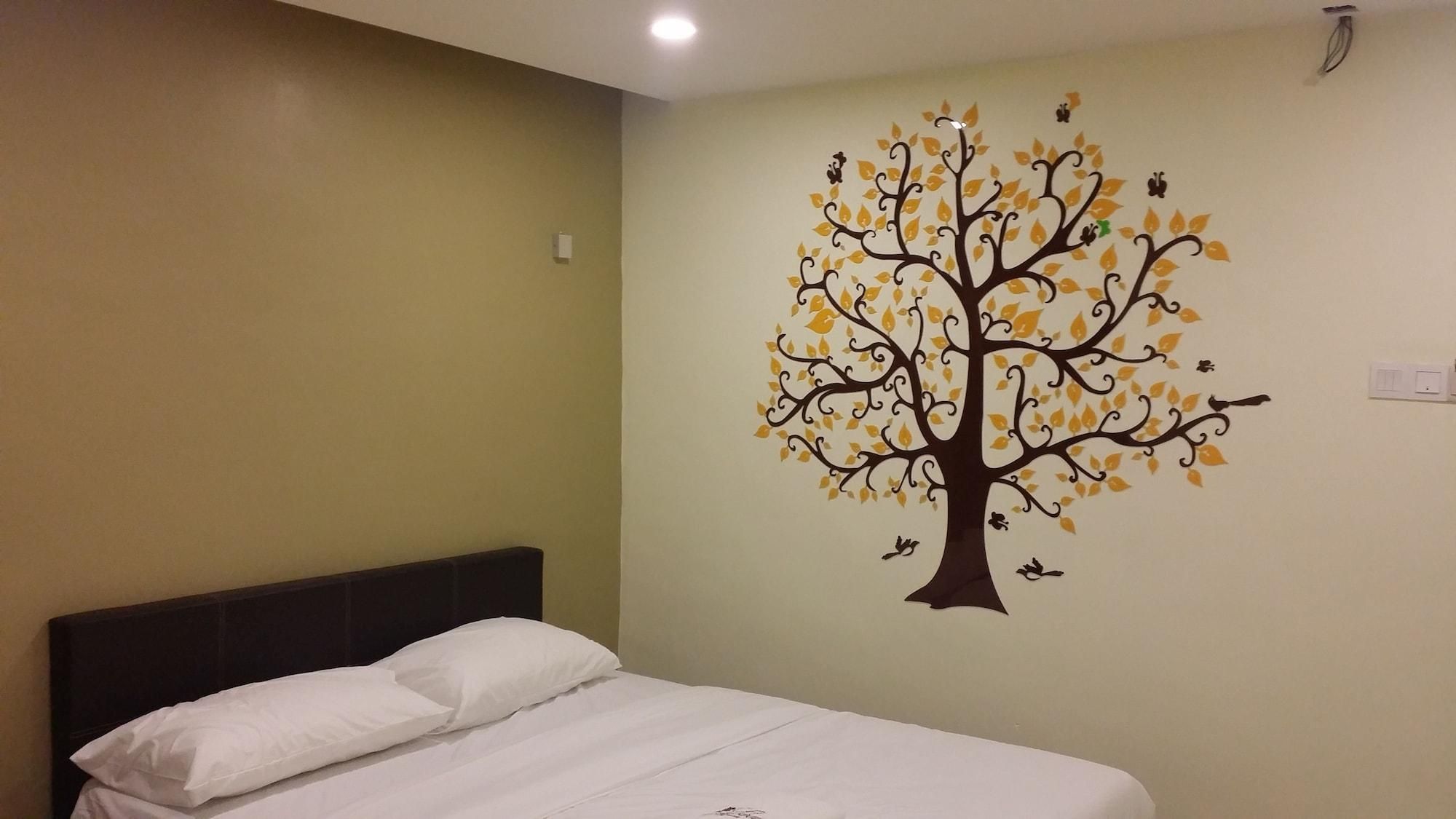 Quarto com cama, parede com mural de árvore e interruptor de luz.