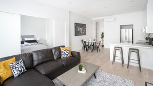 Um apartamento moderno com sala de estar, espaço para refeições e cozinha compacta.