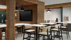 Interior moderno de restaurante com divisórias de ripas de madeira, luminárias pendentes pretas e uma televisão de tela plana na parede.
