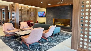 Uma sala de estar moderna com teto de madeira, uma televisão de tela plana grande e uma lareira.