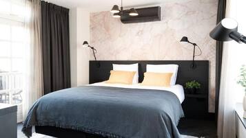 Quarto moderno com uma cama grande, duas luminárias de cabeceira, ar condicionado no teto e vista para uma varanda.