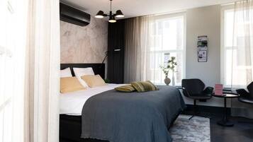 Quarto de hotel moderno com uma cama grande, uma escrivaninha e uma cadeira.