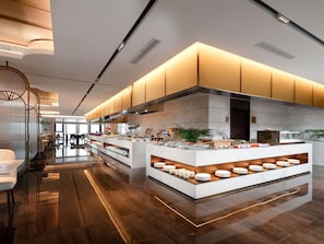 Cozinha moderna com ilha central, armários de madeira e uma vitrine de vidro.